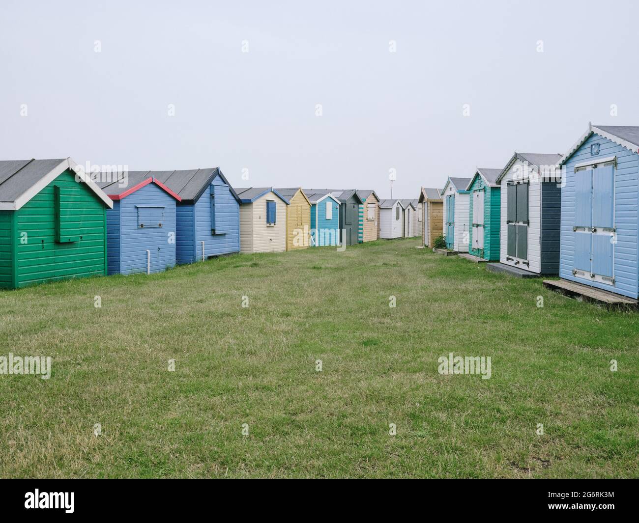 Closed up painted beach huts on a grey day in the wet UK weather Stock ...