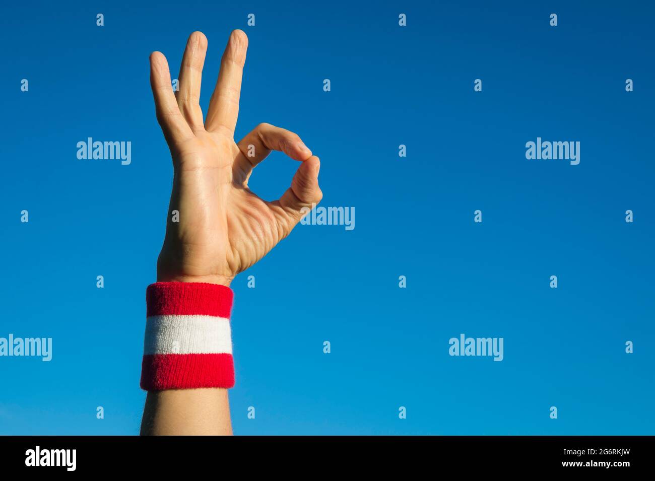 Japanese athlete wearing red and white colored wristbands making okay ...