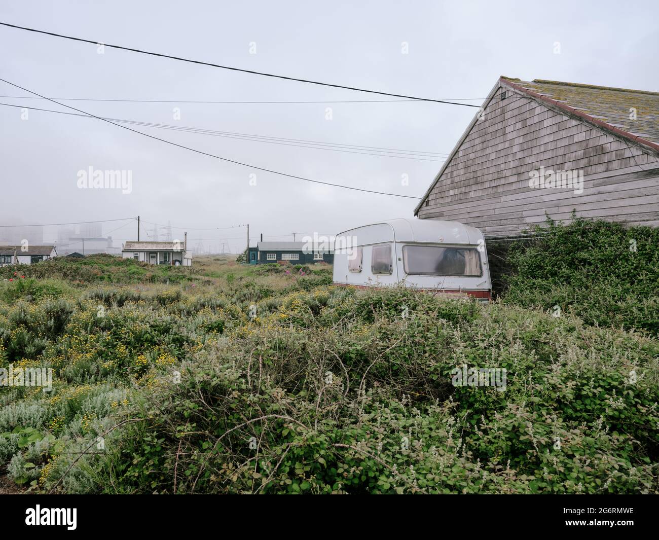 The timber shacks and a lone overgrown caravan with telephone lines at ...