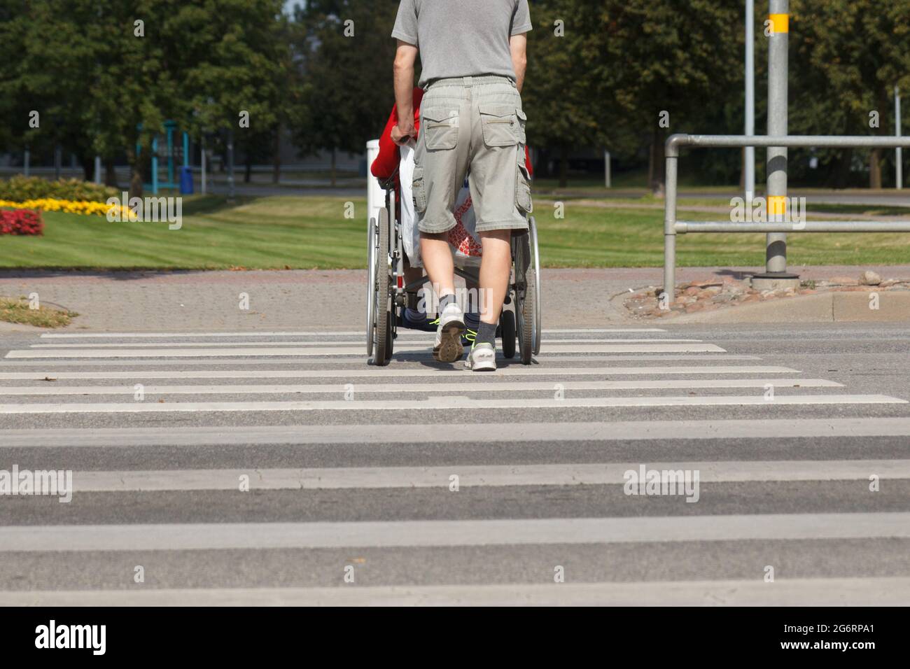 A man pushes wheelchair with disabled Stock Photo - Alamy