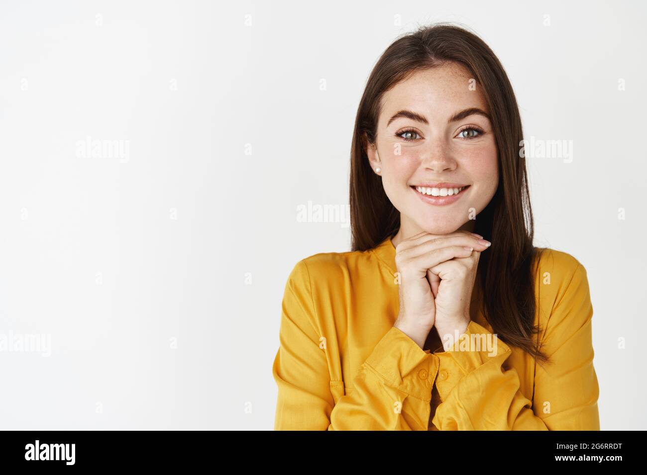 Close-up of happy and dreamy girl looking at camera with admiration ...