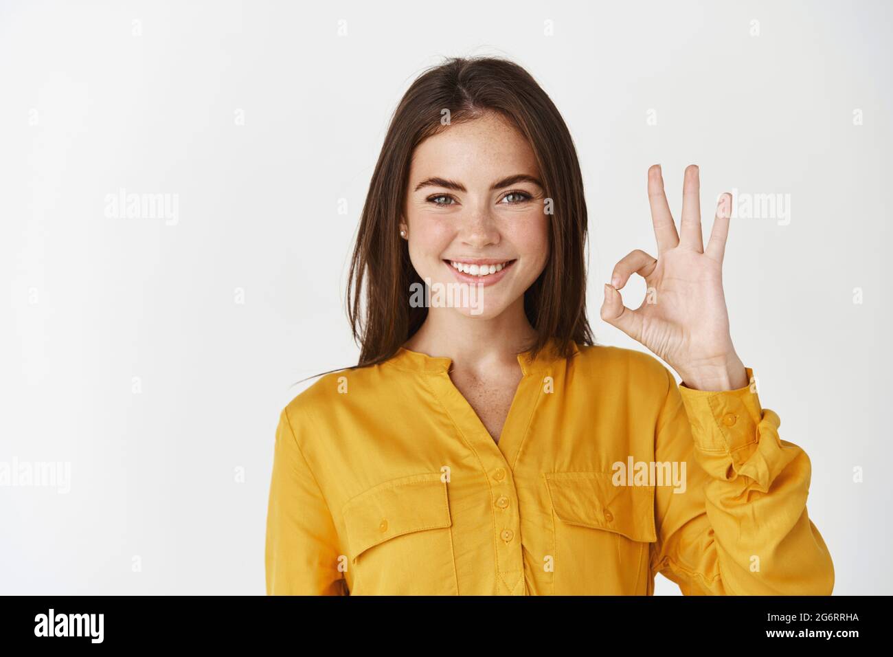 Young confident woman smiling, showing okay gesture, saying yes or ...