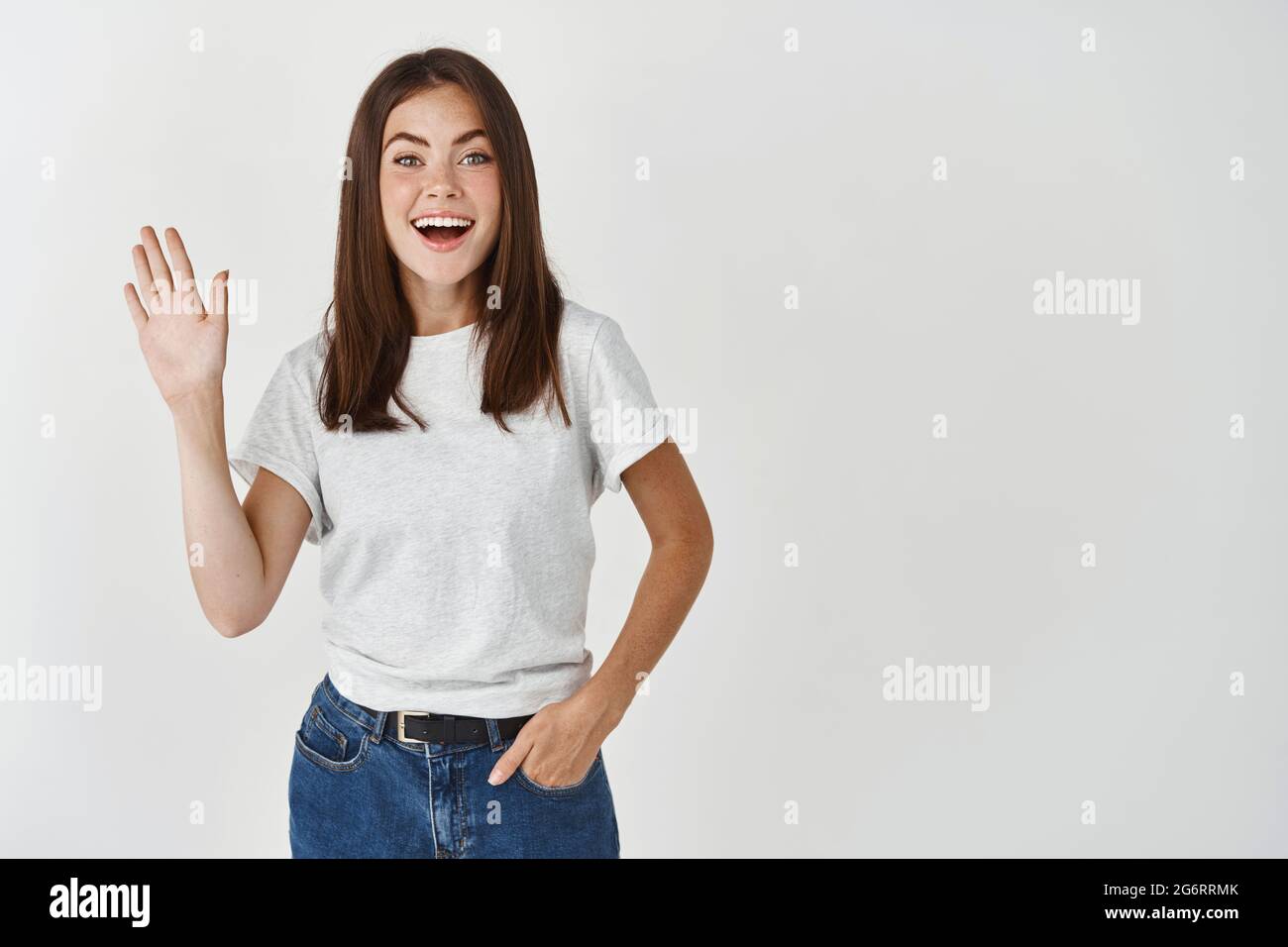 Friendly girl saying hi. Portrait of cheerful european woman in t-shirt ...