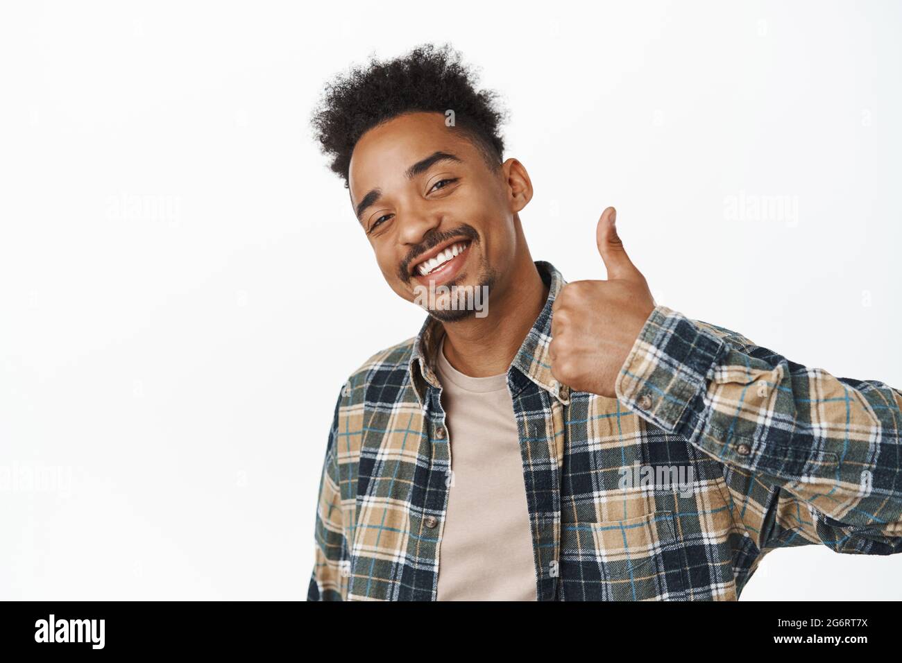 Portrait of pleased african american man smiling satisfied, say yes ...