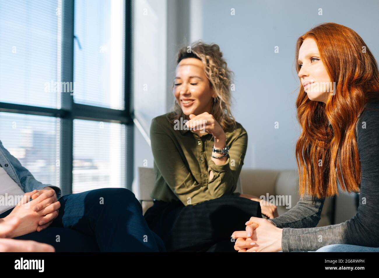 Close-up face young women listening intently to colleagues during ...