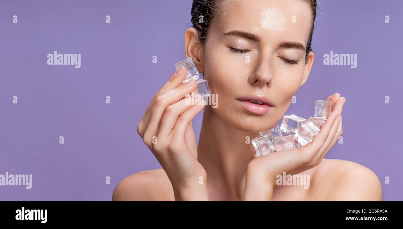 Beautiful woman with natural looking makeup holding ice cubes near face ...