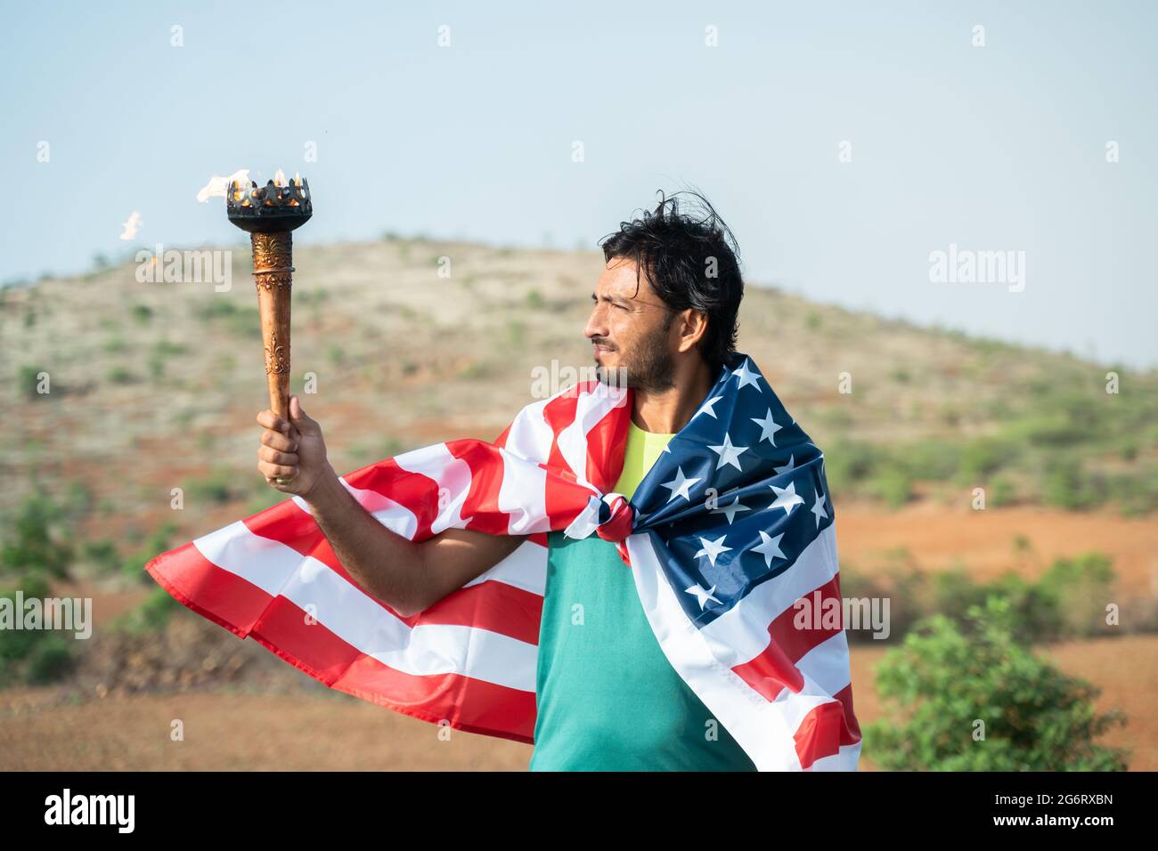 young athlete holding sports flame torch and looking with USA or ...