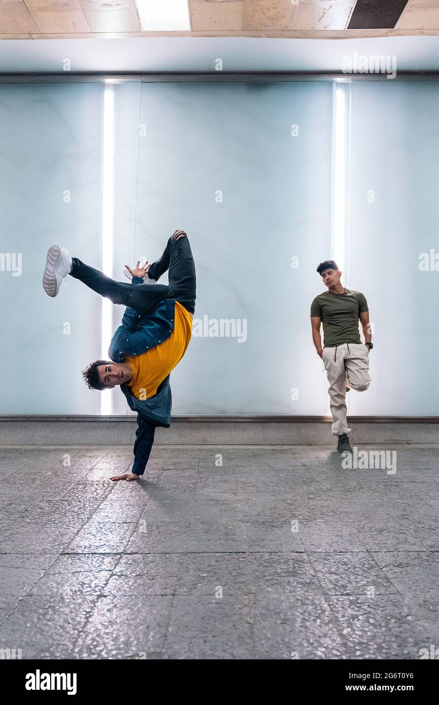 Two multi-ethnic friends dancing break dance and having fun against ...