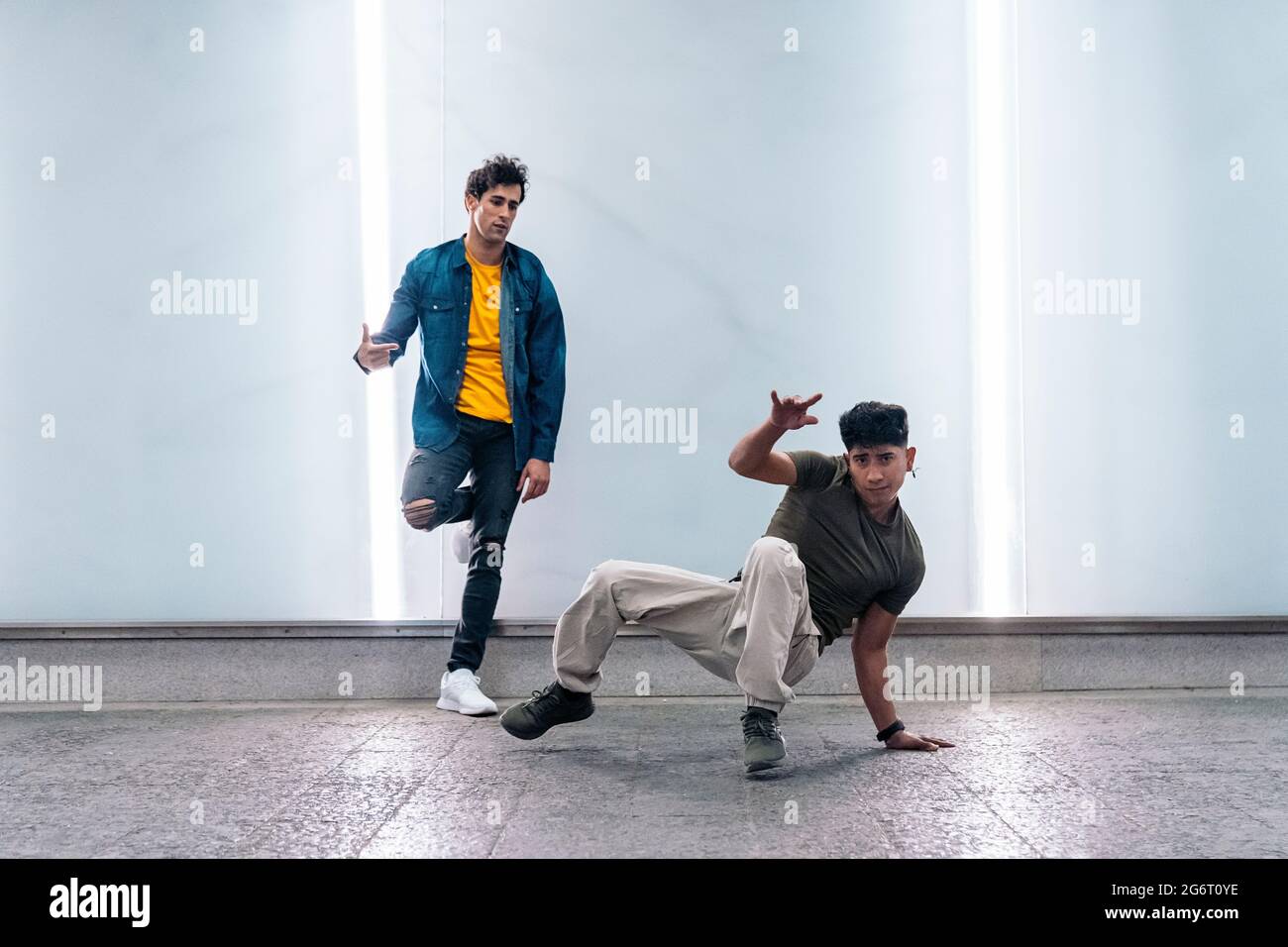 Two multi-ethnic friends dancing break dance and having fun against ...