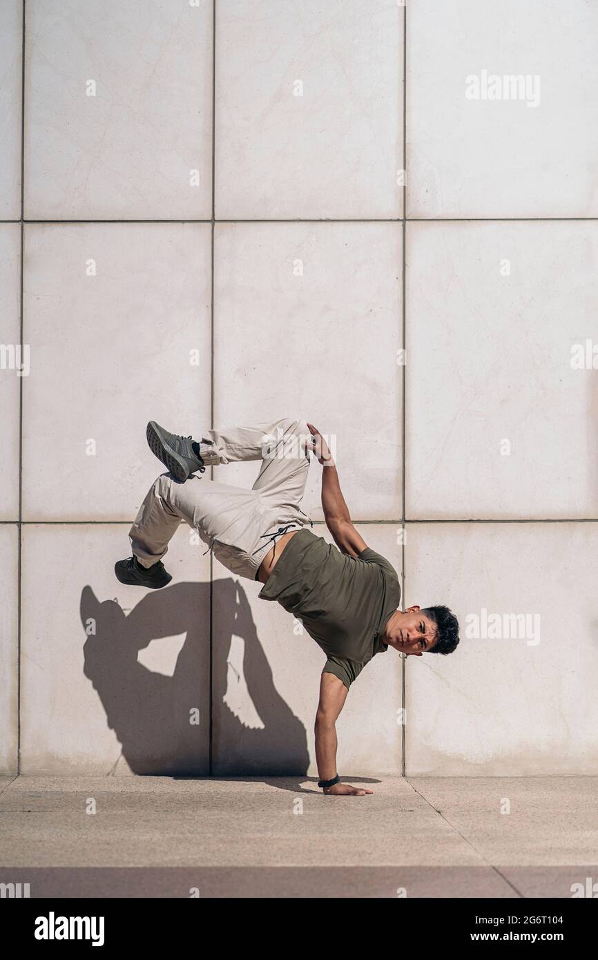 Cool break dancer practicing in the street and having fun. He is ...