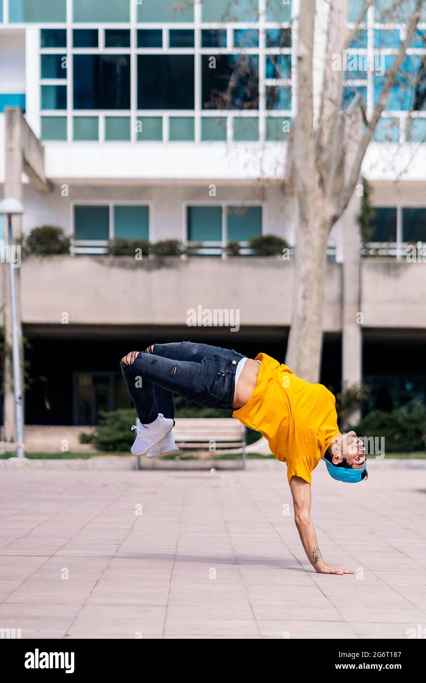 Confident young boy doing break dance moves in the park and having fun ...