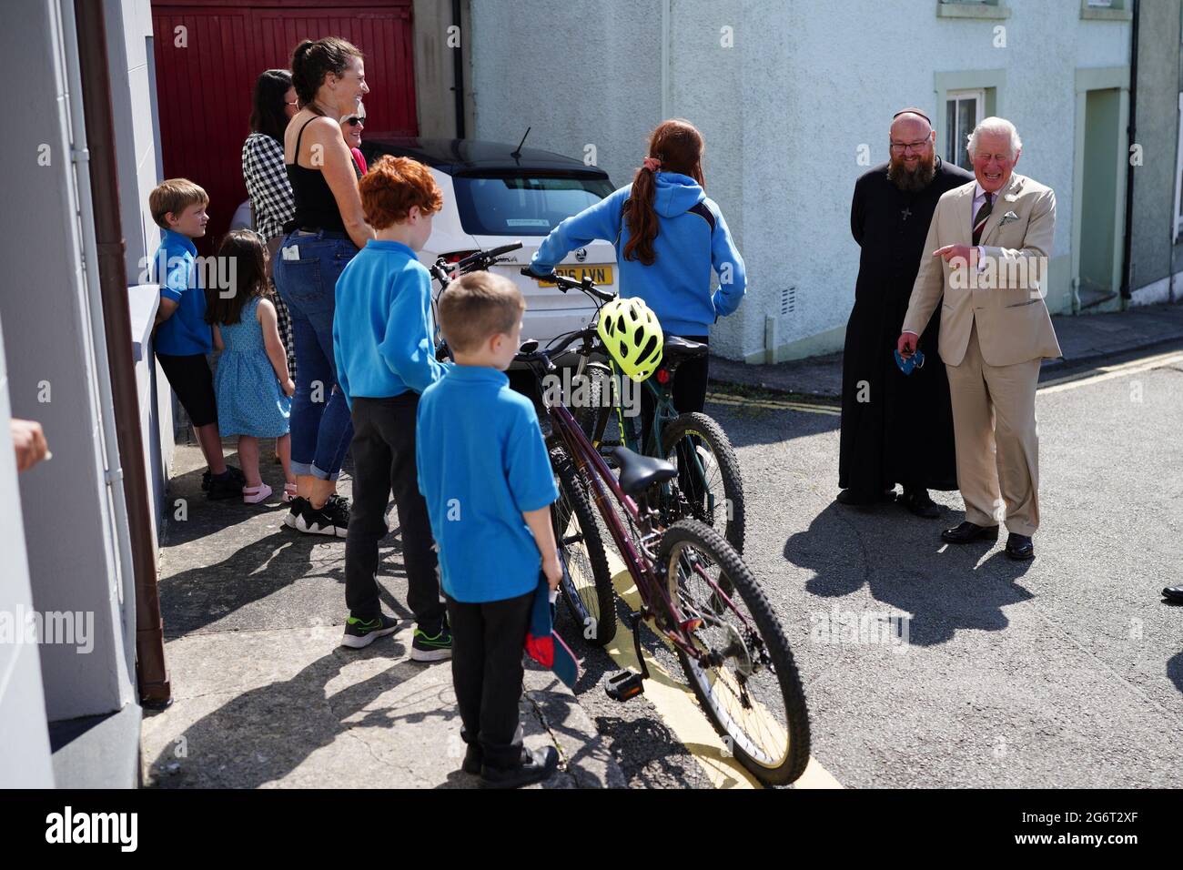 The Prince of Wales, with Father Neil Hook (second right), stops to ...