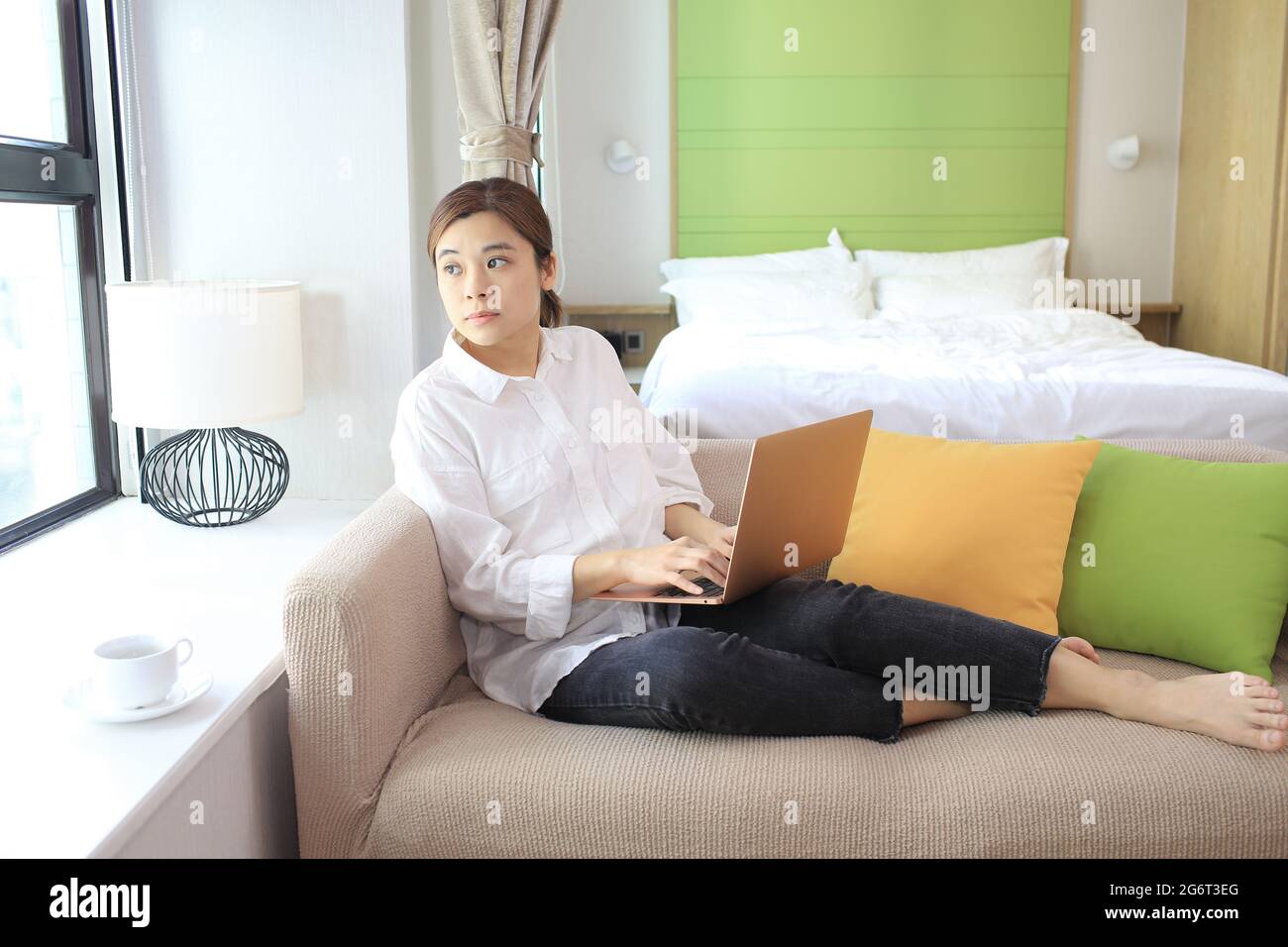 asian woman lying near the window and think when she is working at home ...