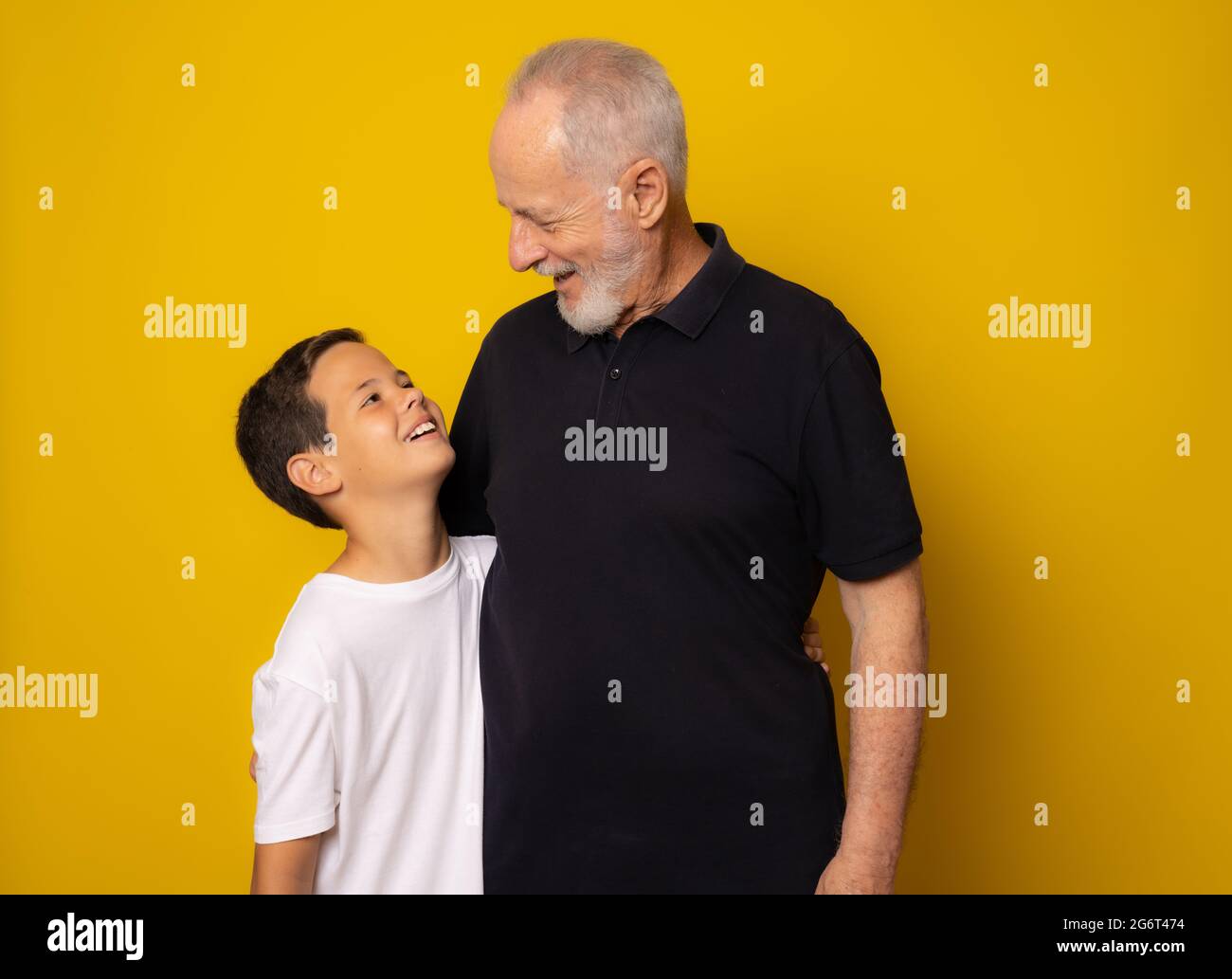 Grandfather and grandson smiling over yellow background Stock Photo - Alamy