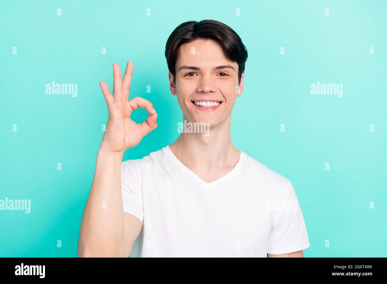 Photo of funny brunet hairdo teen guy show okey sign wear white t-shirt ...