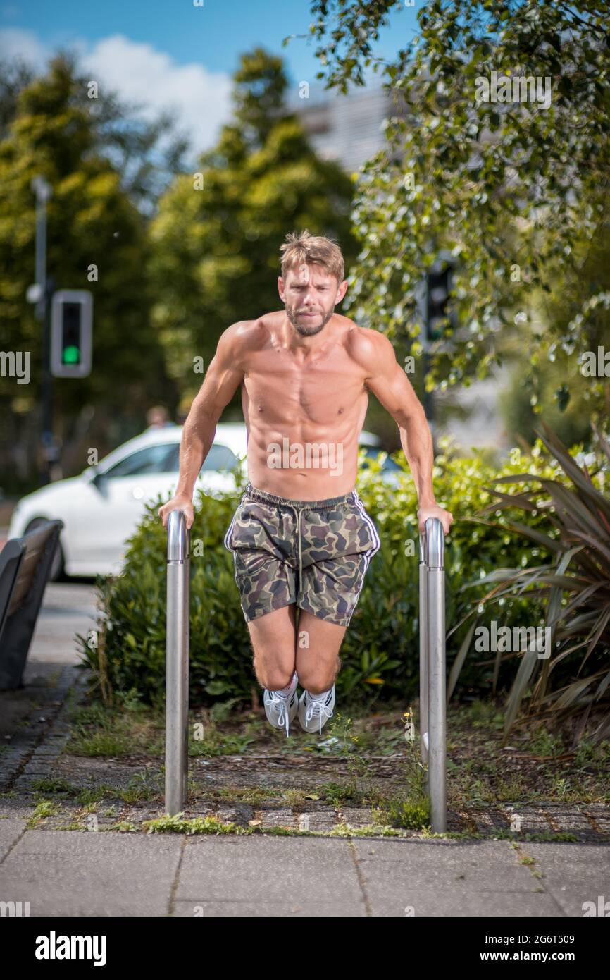 Man Doing Calisthenics Outdoors. Guy working out in the Street. Sport ...