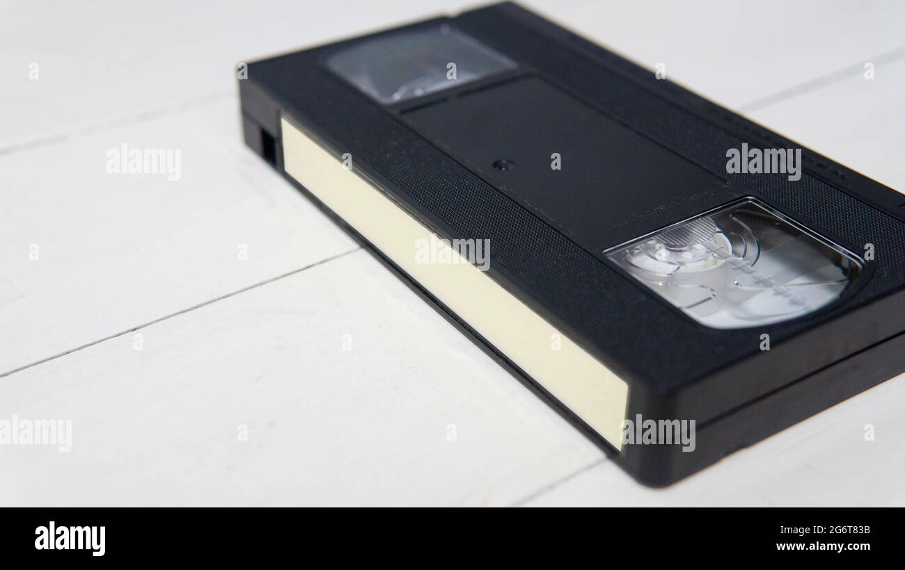 Close view of an old VHS tape with a blank label over a white wooden ...