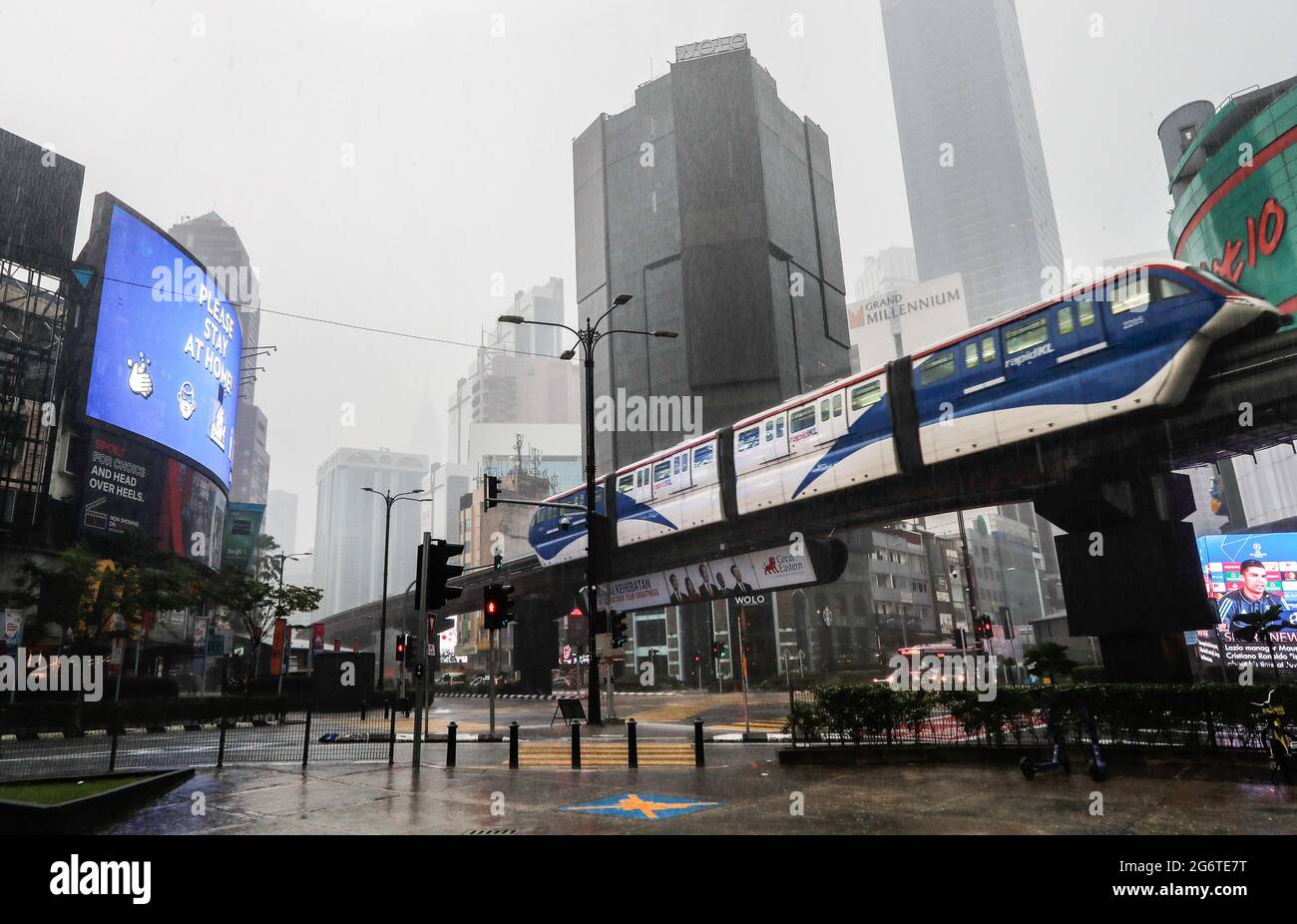 A light transit train moves past the deserted street during heavy ...