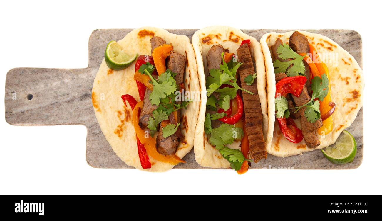 Three Fajitas on a Marble Serving Board Isolated on a White Background ...