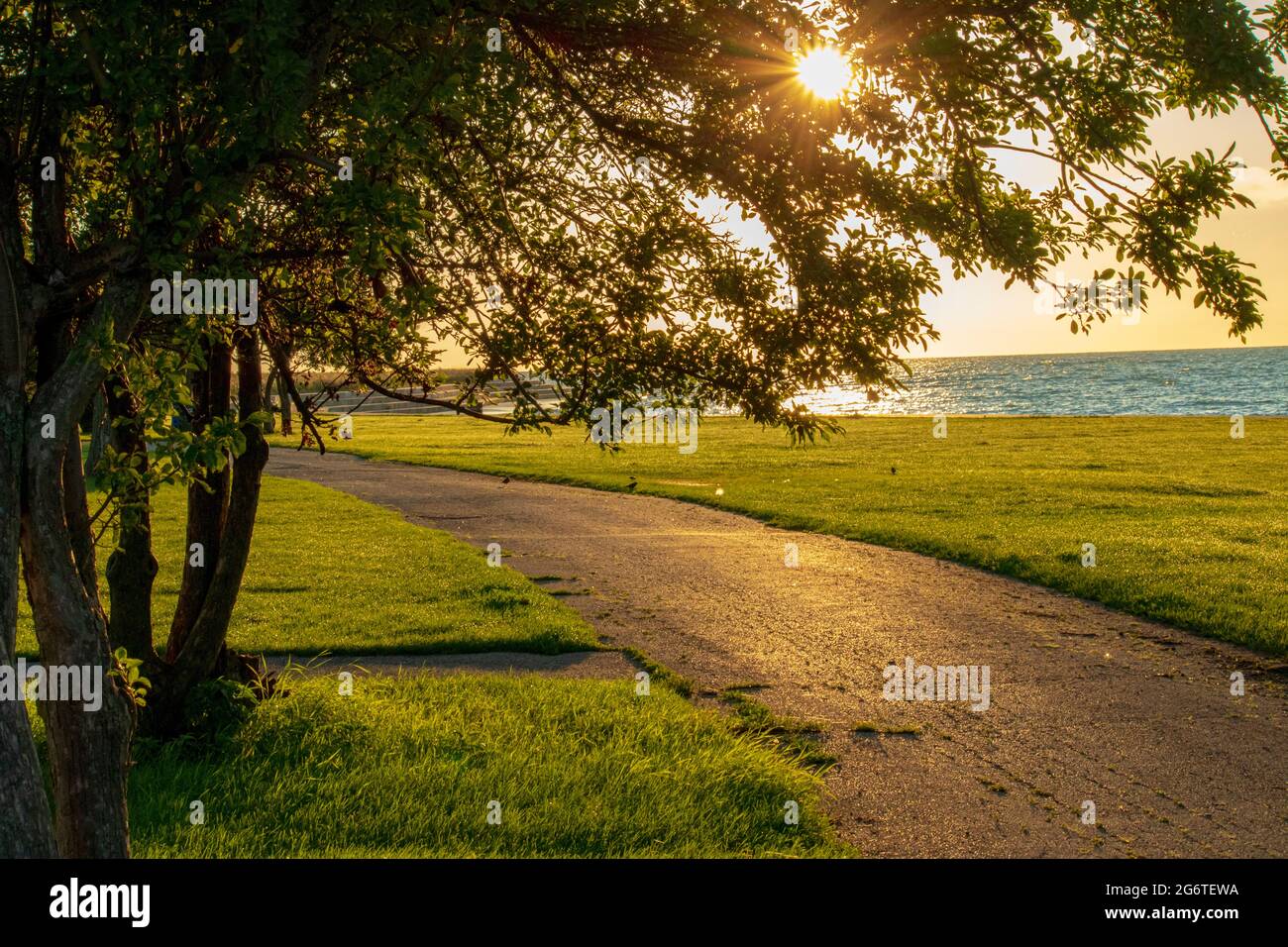Sun Rising over a lakefront Path Stock Photo - Alamy