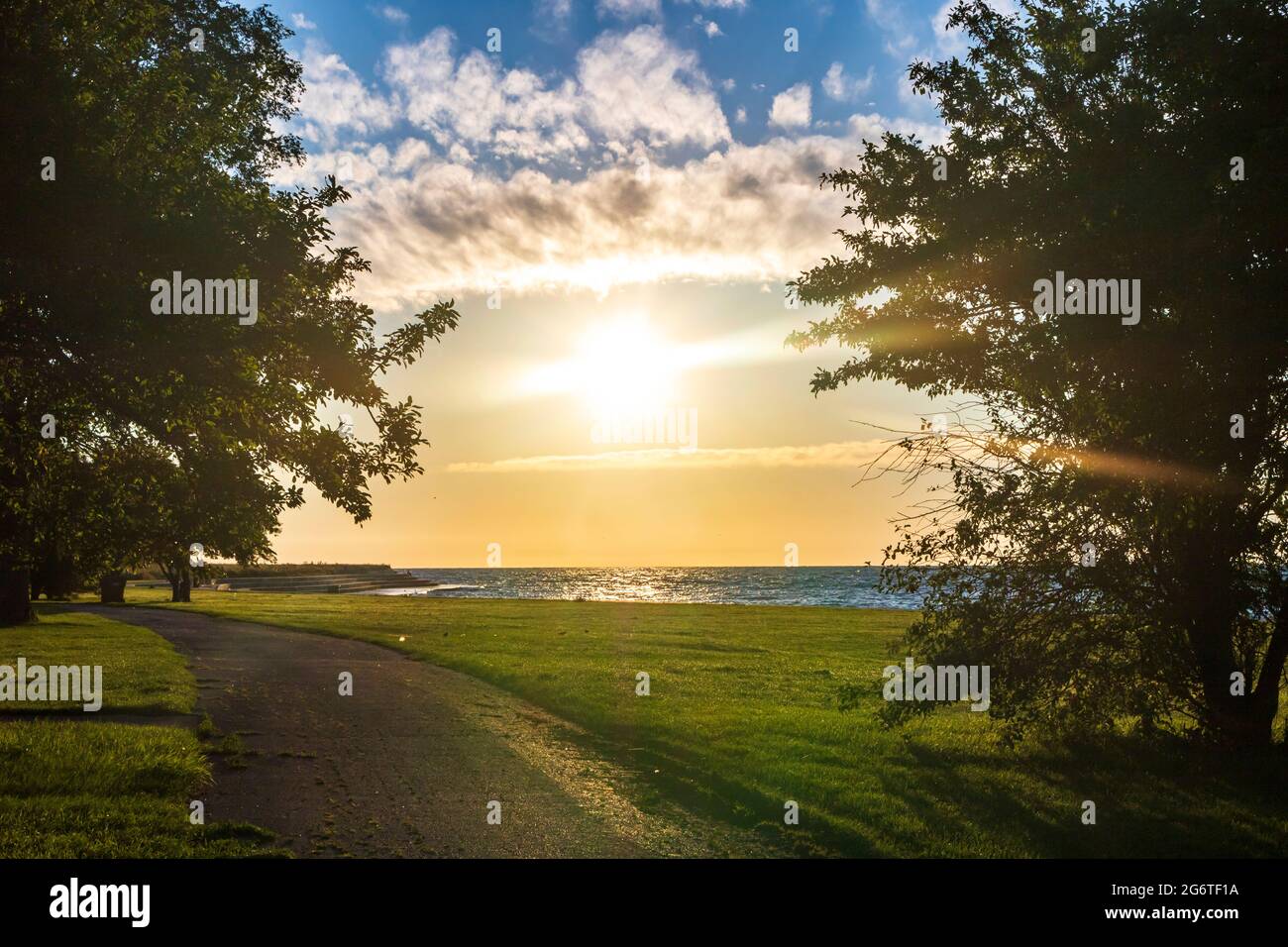 Sunrise along a lake front path Stock Photo - Alamy