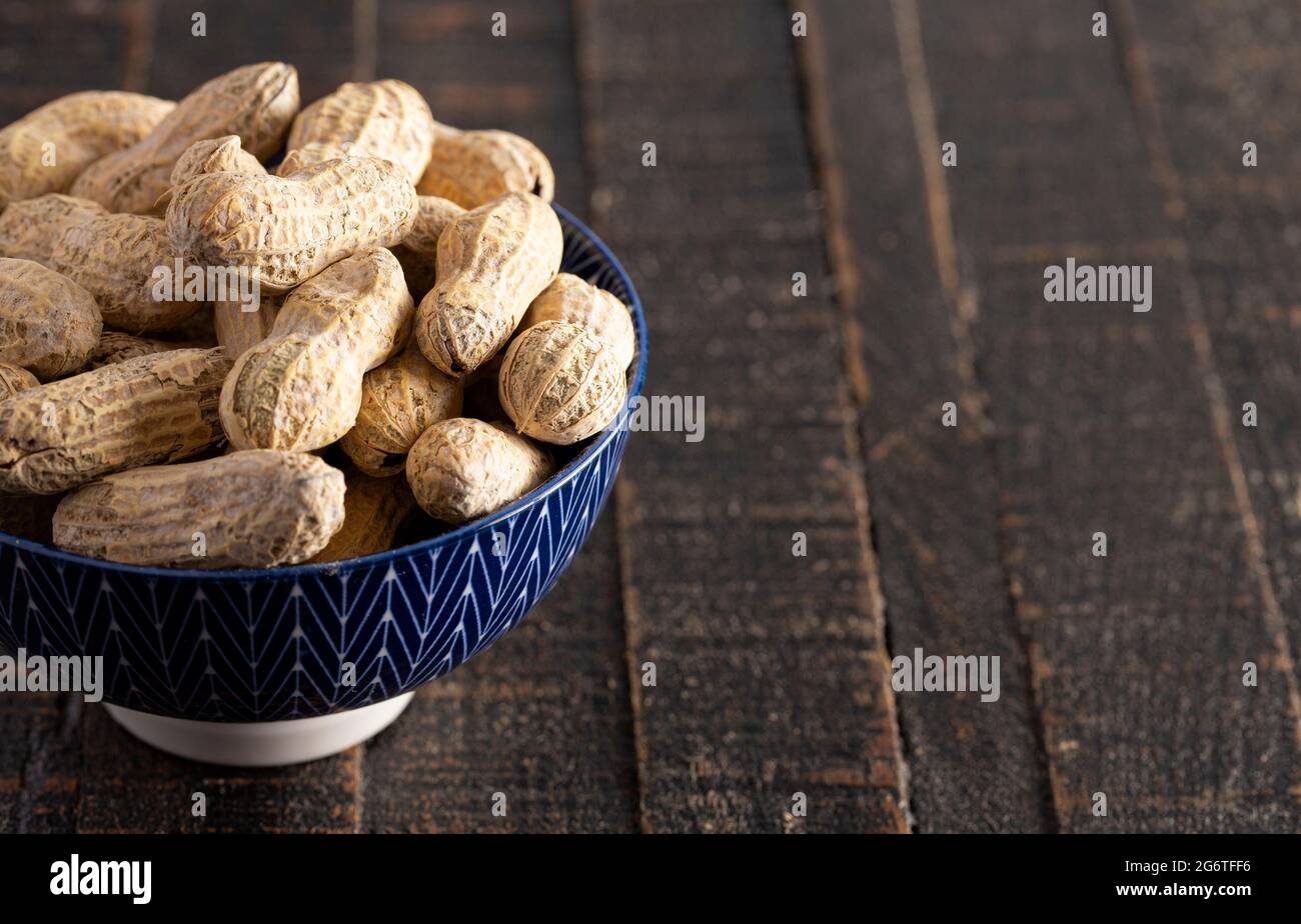 Raw In Shell Peanuts on a Rustic Wooden Kitchen Table Stock Photo - Alamy