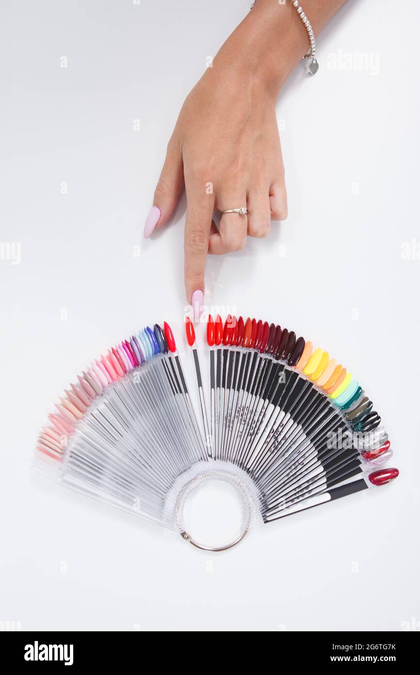 Top view cropped shot of female hand pointing on a color on nail polish ...