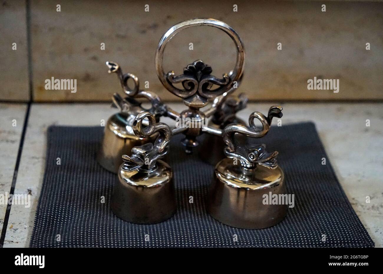 Set of antique silver altar bells with fishes on top in a catholic ...