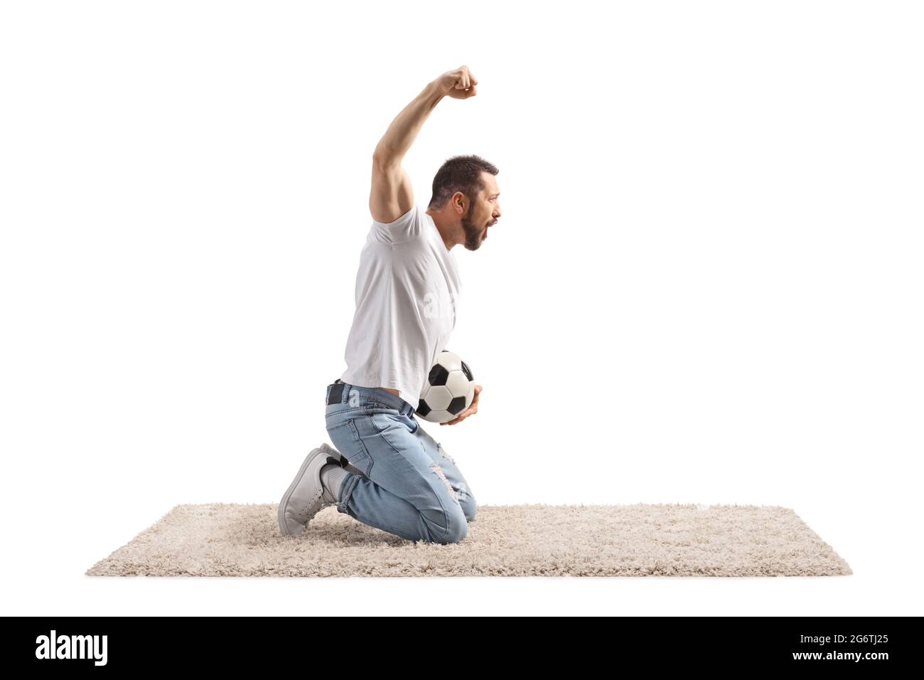 Young man holding a football, kneeling and cheering isolated on white ...