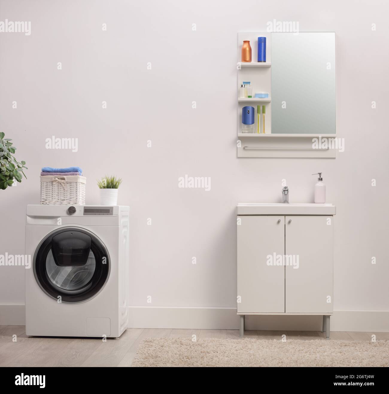 Shot of a minimal bathroom interior with a sink and washing machine ...