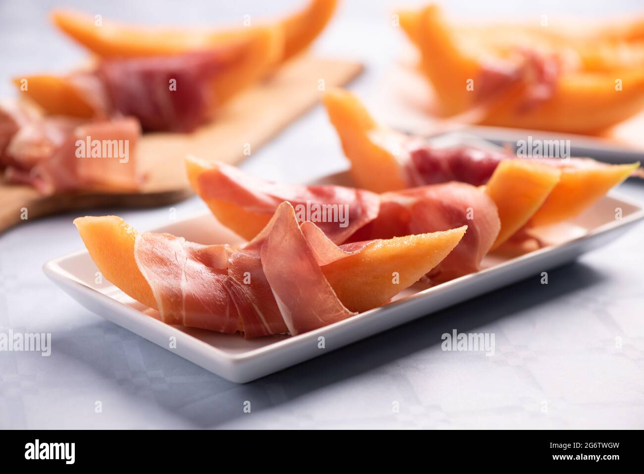 Fresh melon and parma ham on white plate. Close up Stock Photo - Alamy