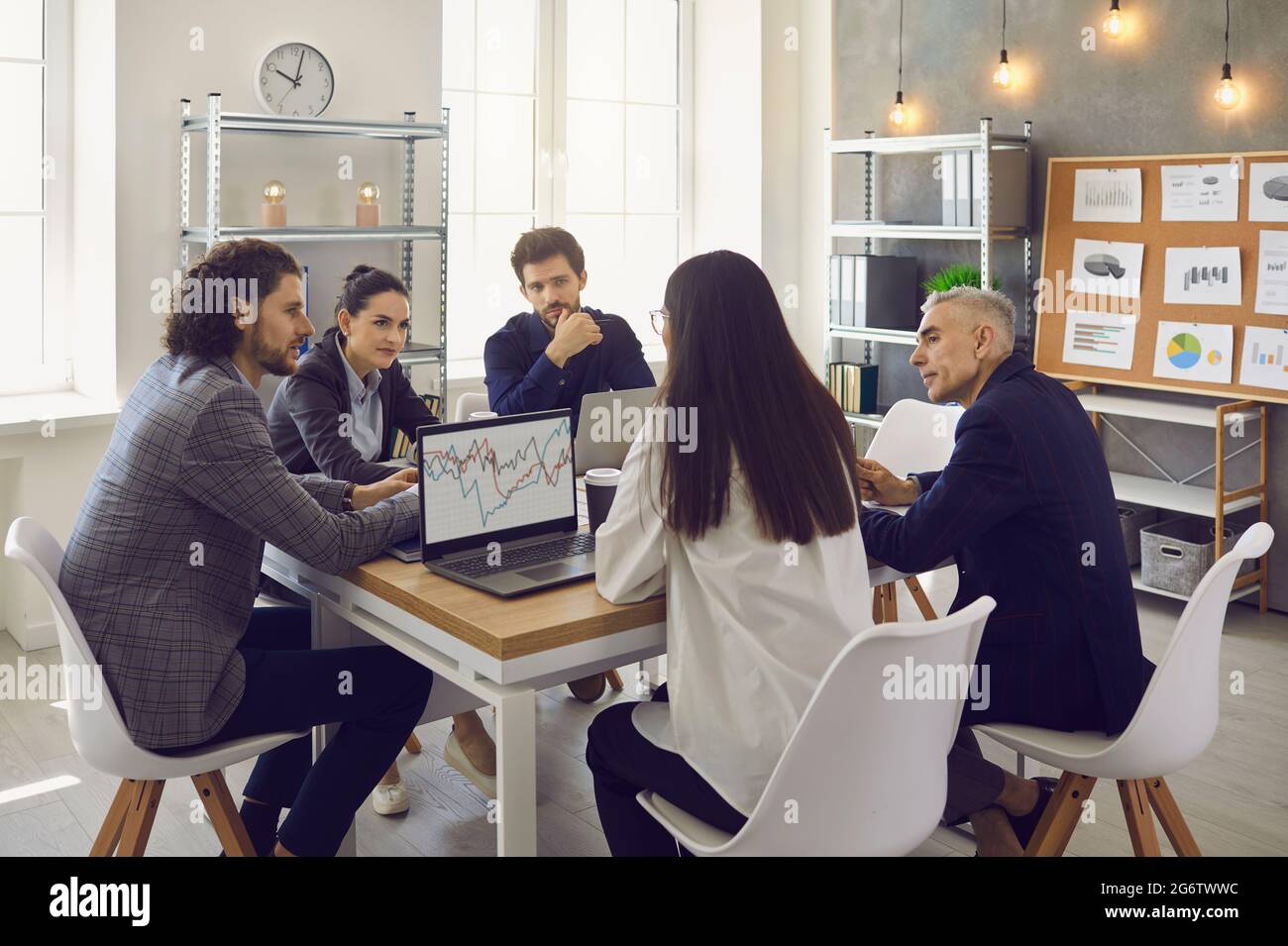 Business team discussing their plans sitting around office table in ...