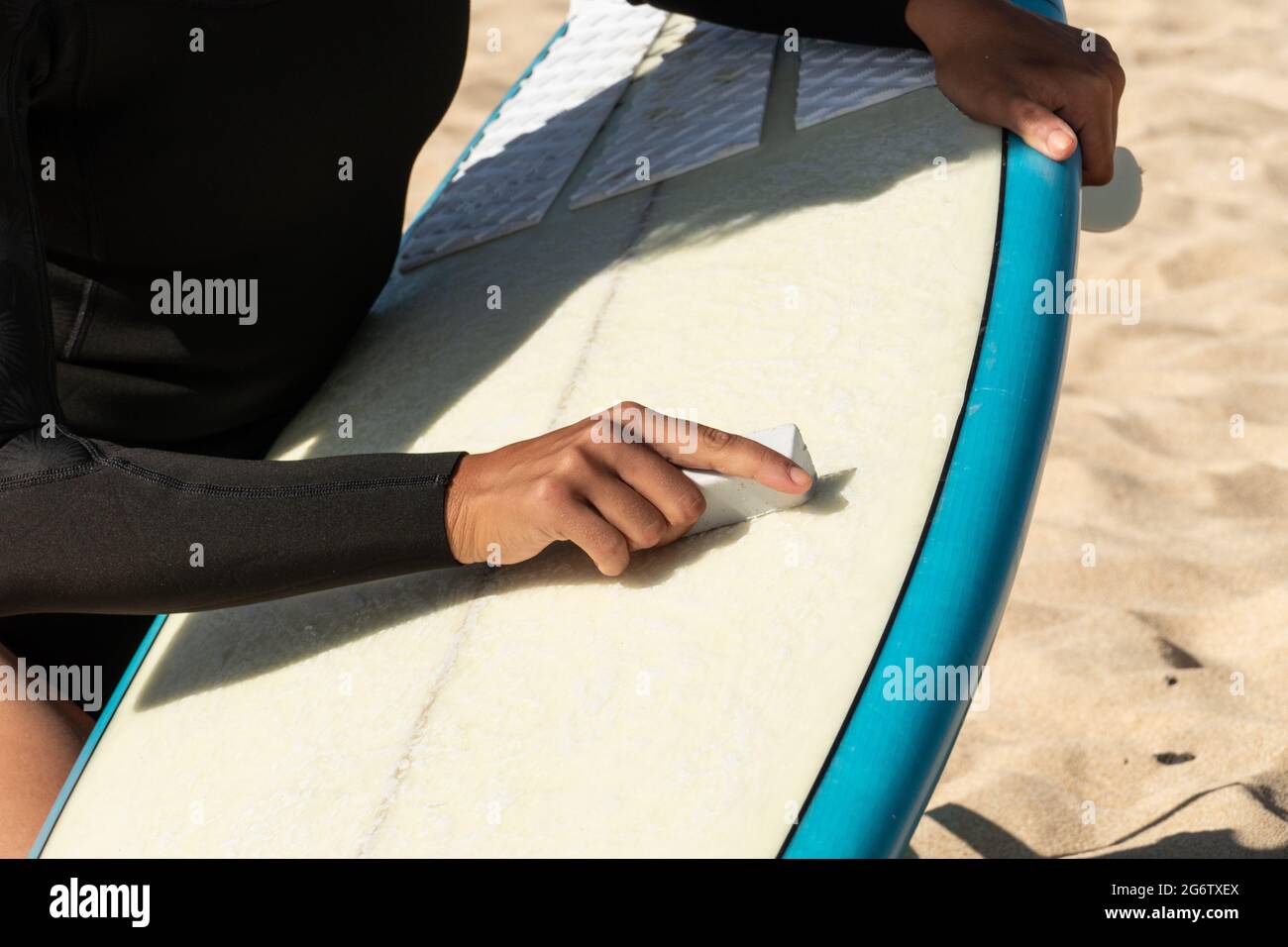 Unrecognizable woman's hands waxing surfboard Stock Photo - Alamy