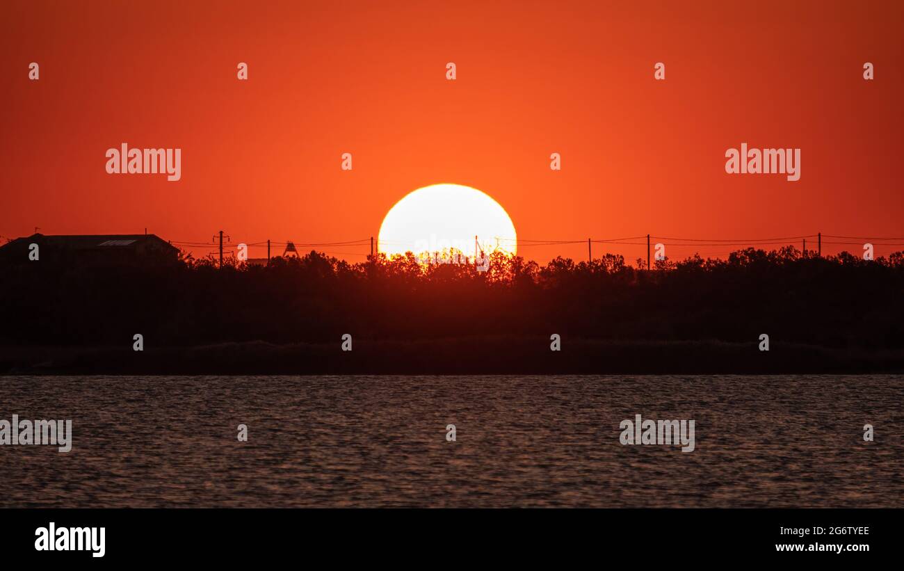 The sun goes down over a lake. Dramatic Sunset Sky Stock Photo - Alamy