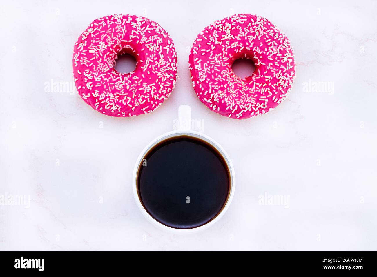 donuts like eyes and a cup of coffee. Top view. Minimalist concept ...