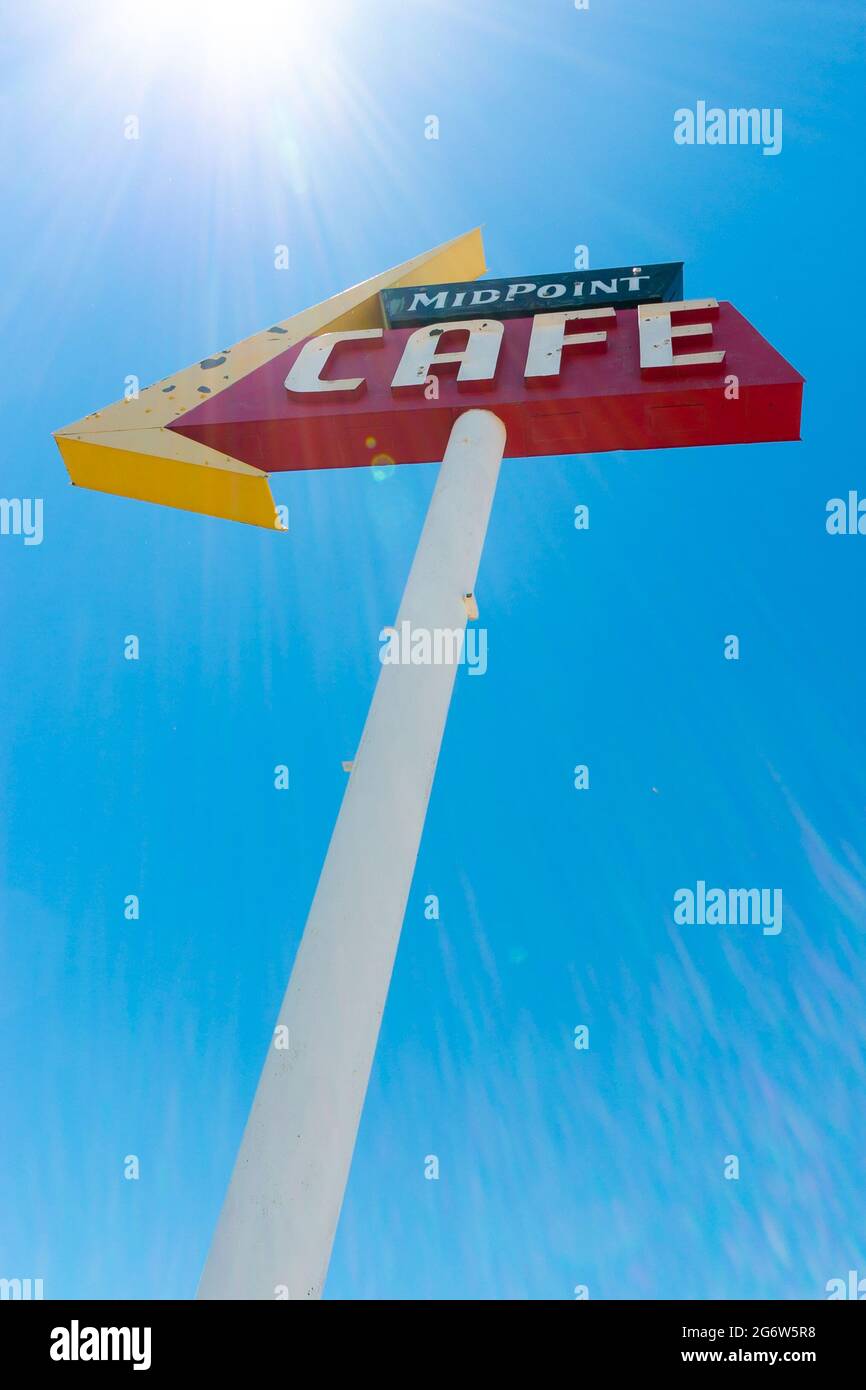 old 1960s cafe sign against bright blue sky in the desert at Midpoint ...