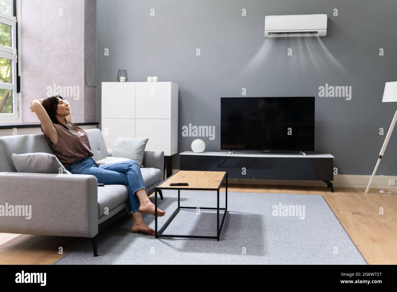Happy Woman Relaxing Under The Air Conditioner Stock Photo - Alamy