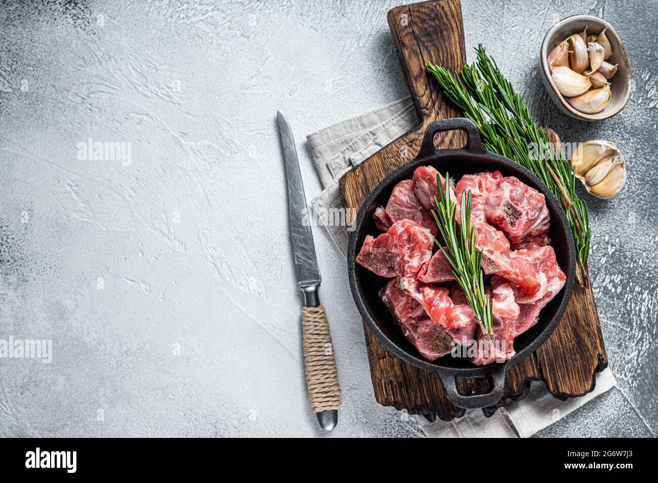 Raw diced meat cubes with bone in a pan. White background. Top View ...
