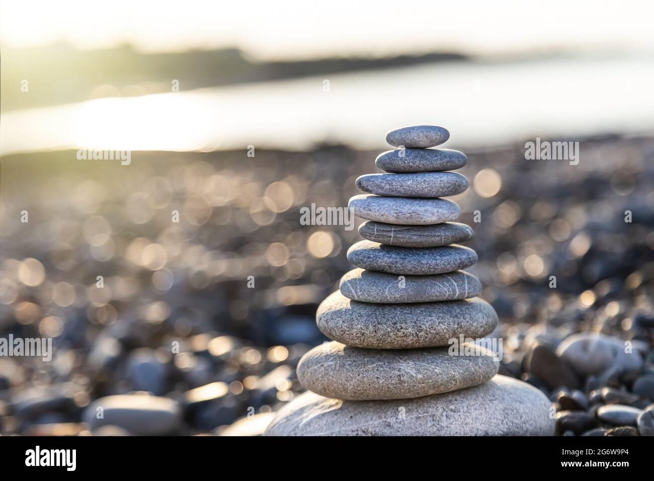 Pyramid of gray pebble stones on the beach of Turkey at sunrise. Zen ...