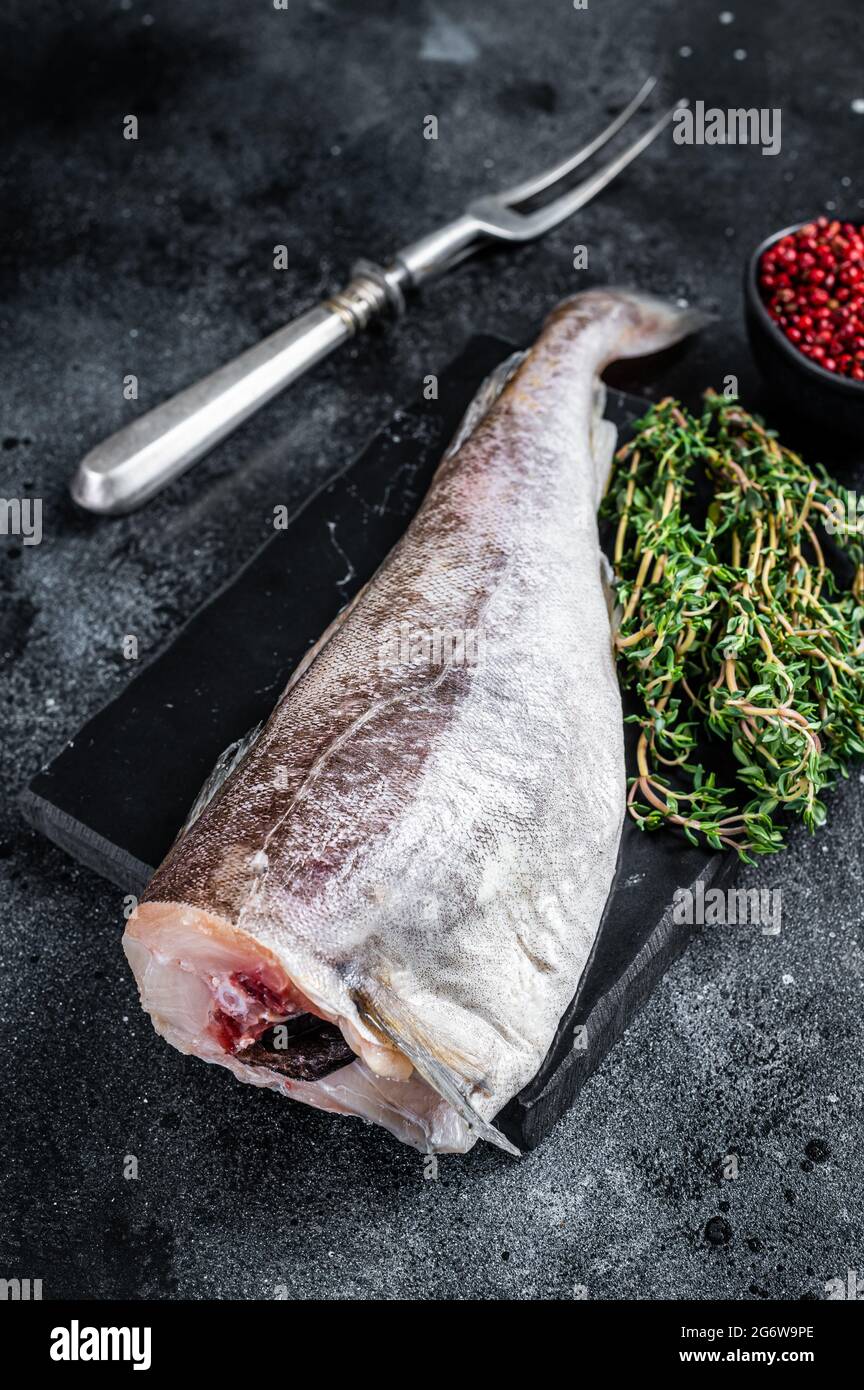 Uncooked Raw cod whole fish on marble board with thyme. Black ...