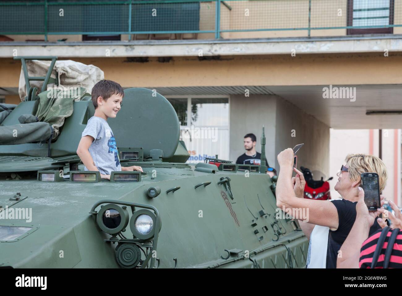 Picture of a child being taken in picture by his parents in a tank of ...