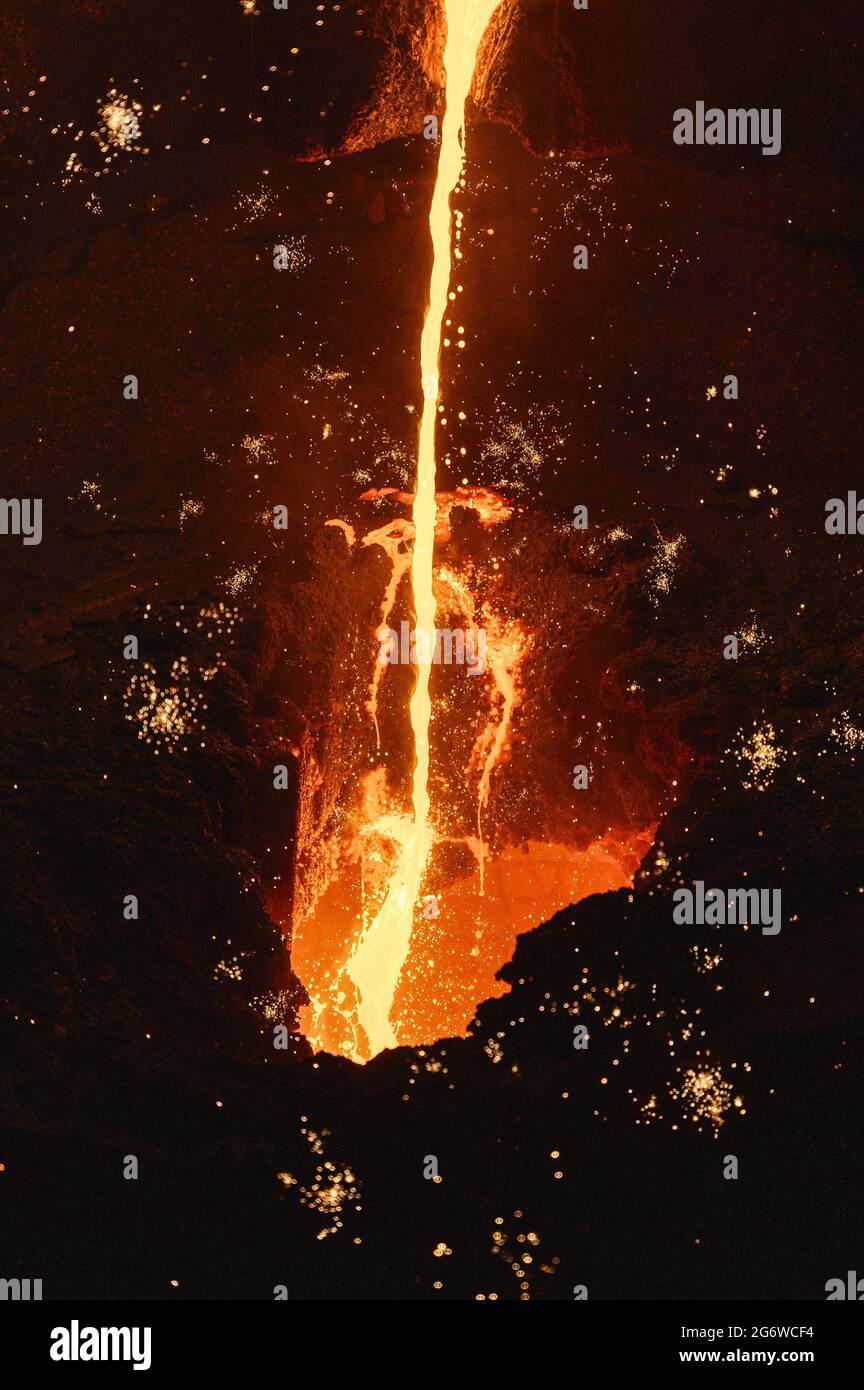 Molten iron flow. Liquid metal is poured into the ladle in a thin ...