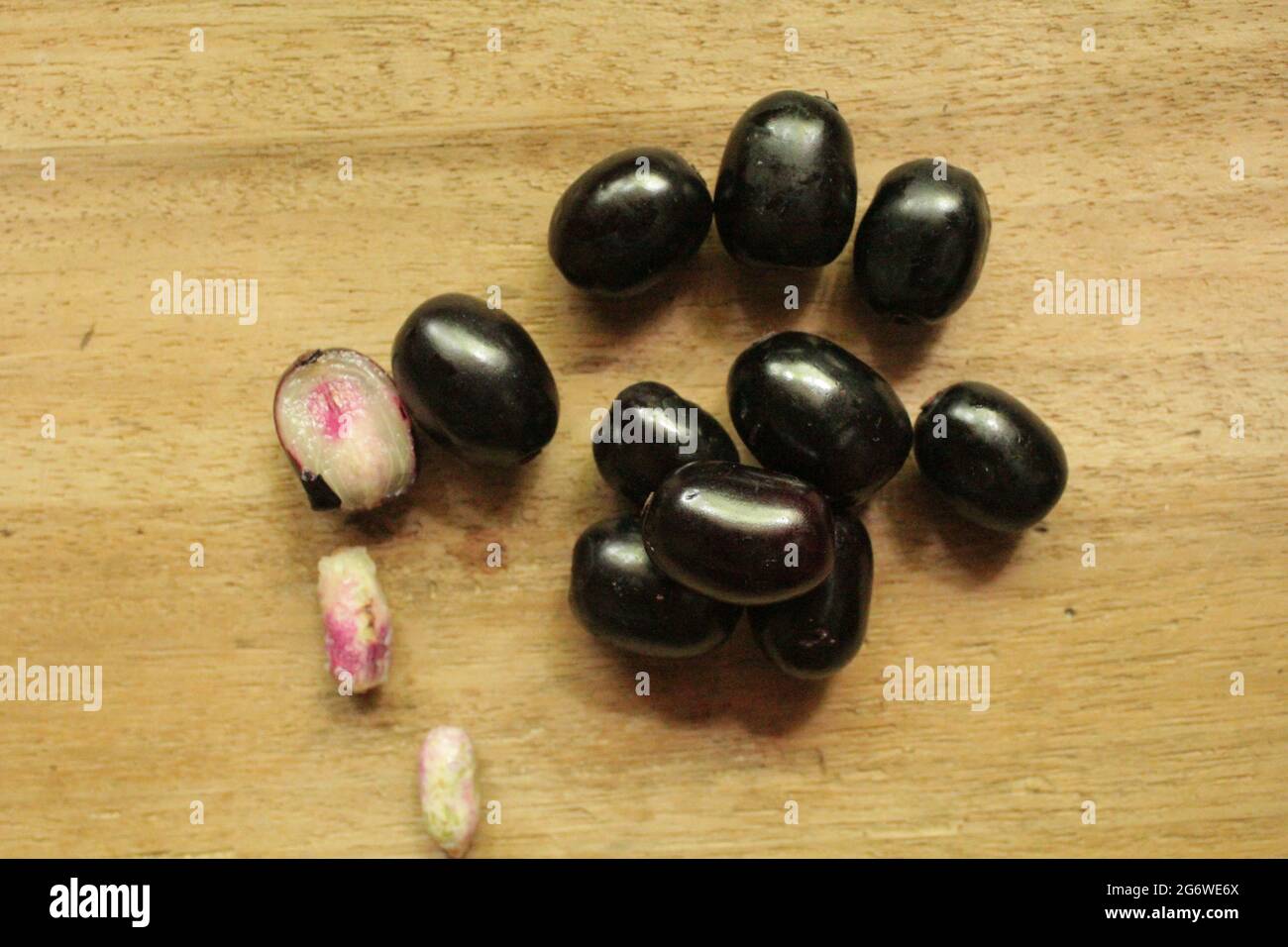 Java plum fruits or syzygium fruit on isolated wooden surface, top view ...