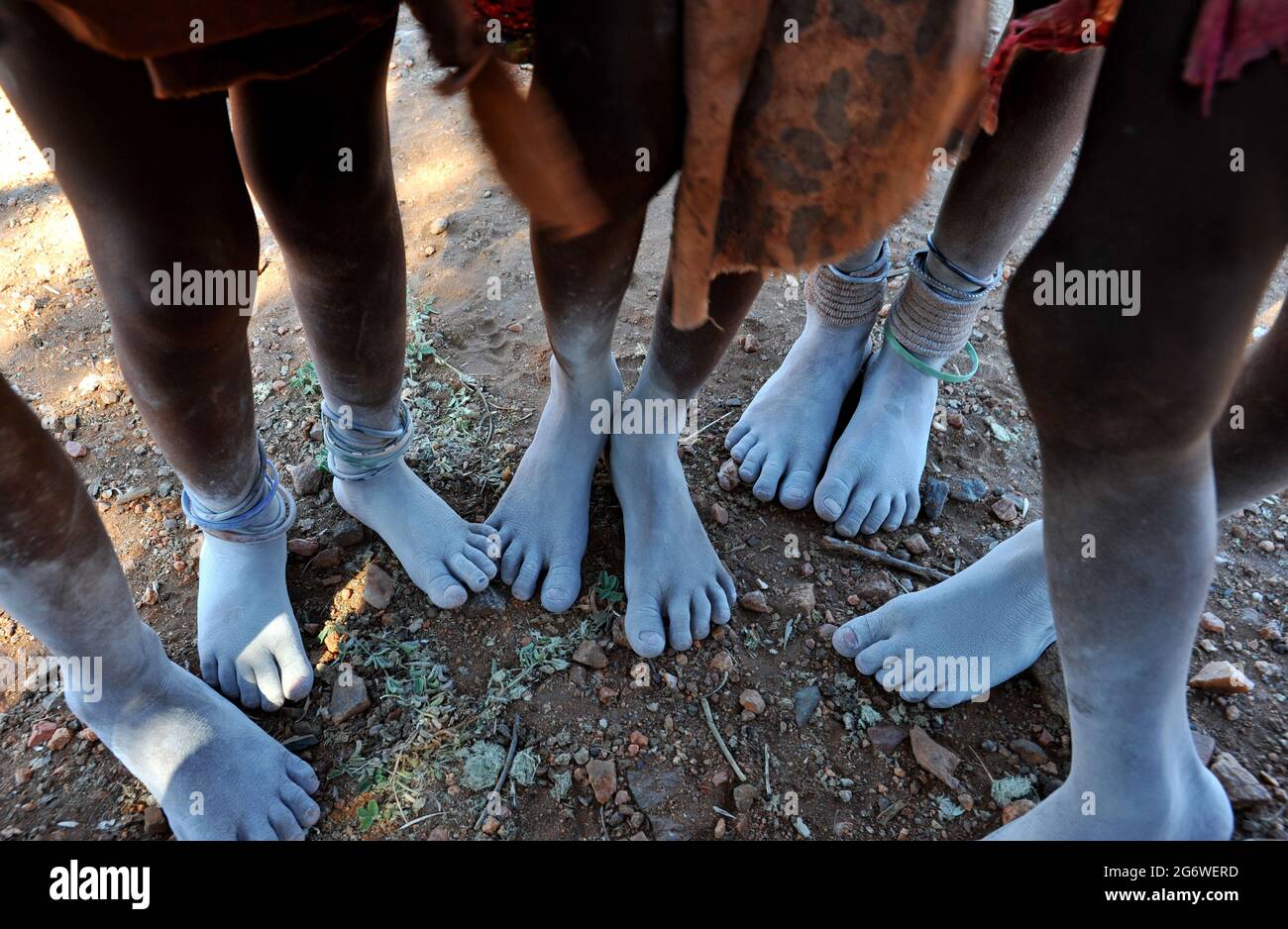 NAMIBIA. YOUNG HIMBAS SHOWING THEIR FEET COVERED WITH ASHES. WALKING ON ...