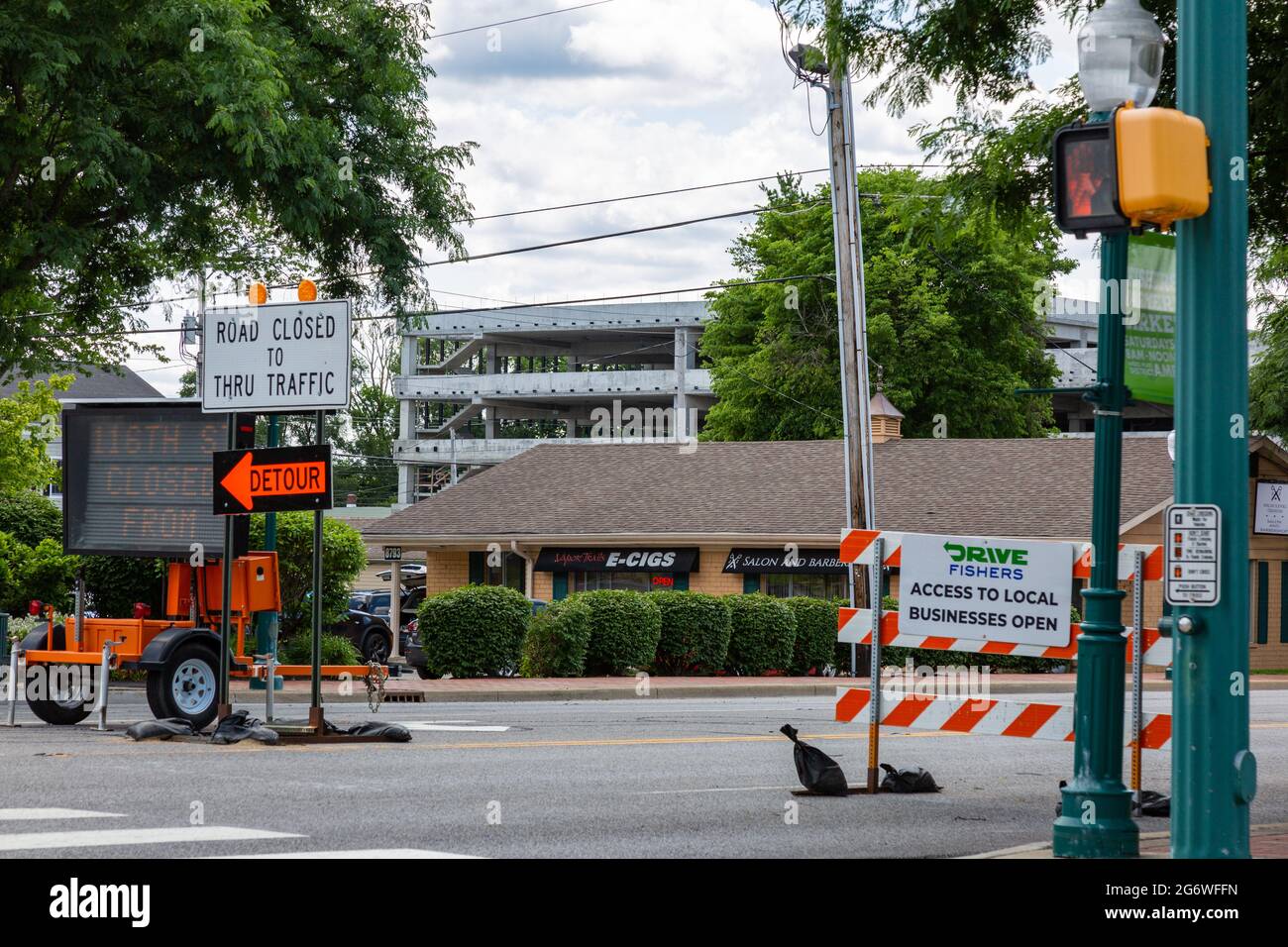 A parking garage under construction can be seen behind these roadwork ...