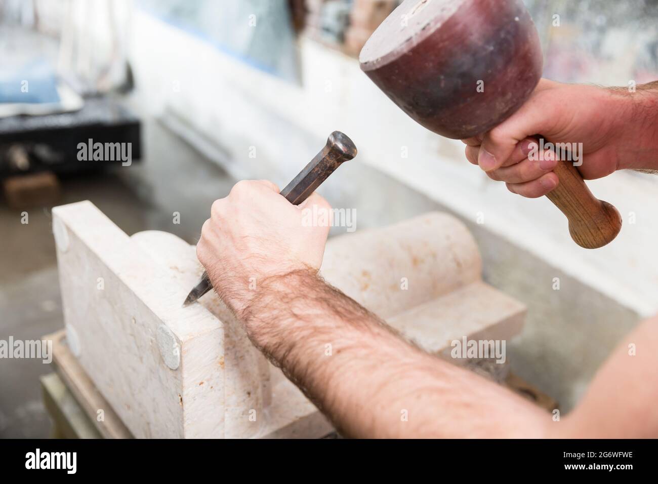 Stone carver working with hammer and chisel at marble column Stock ...