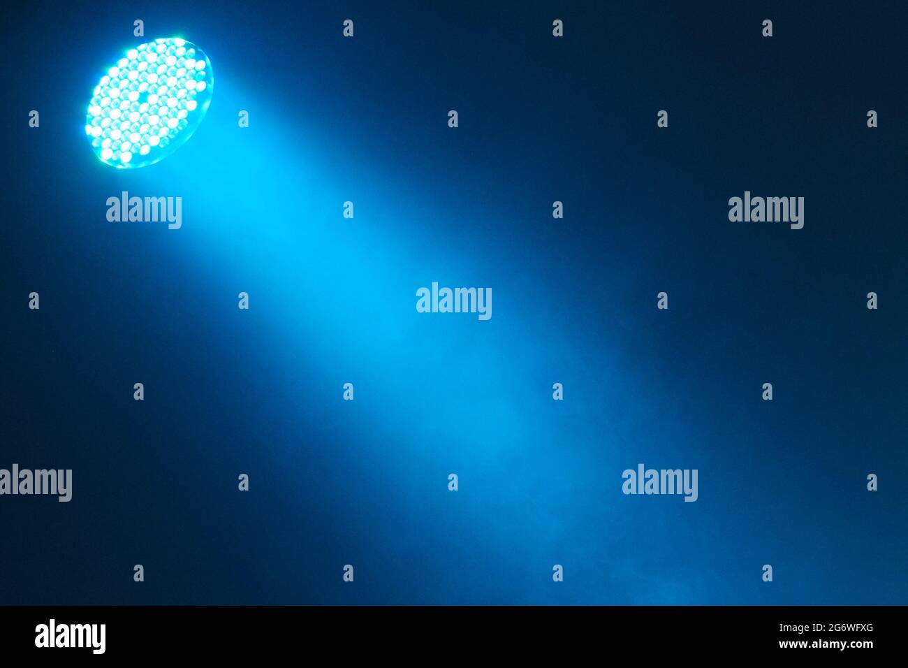 Searchlight beam on a blue background and in clouds of smoke Stock ...