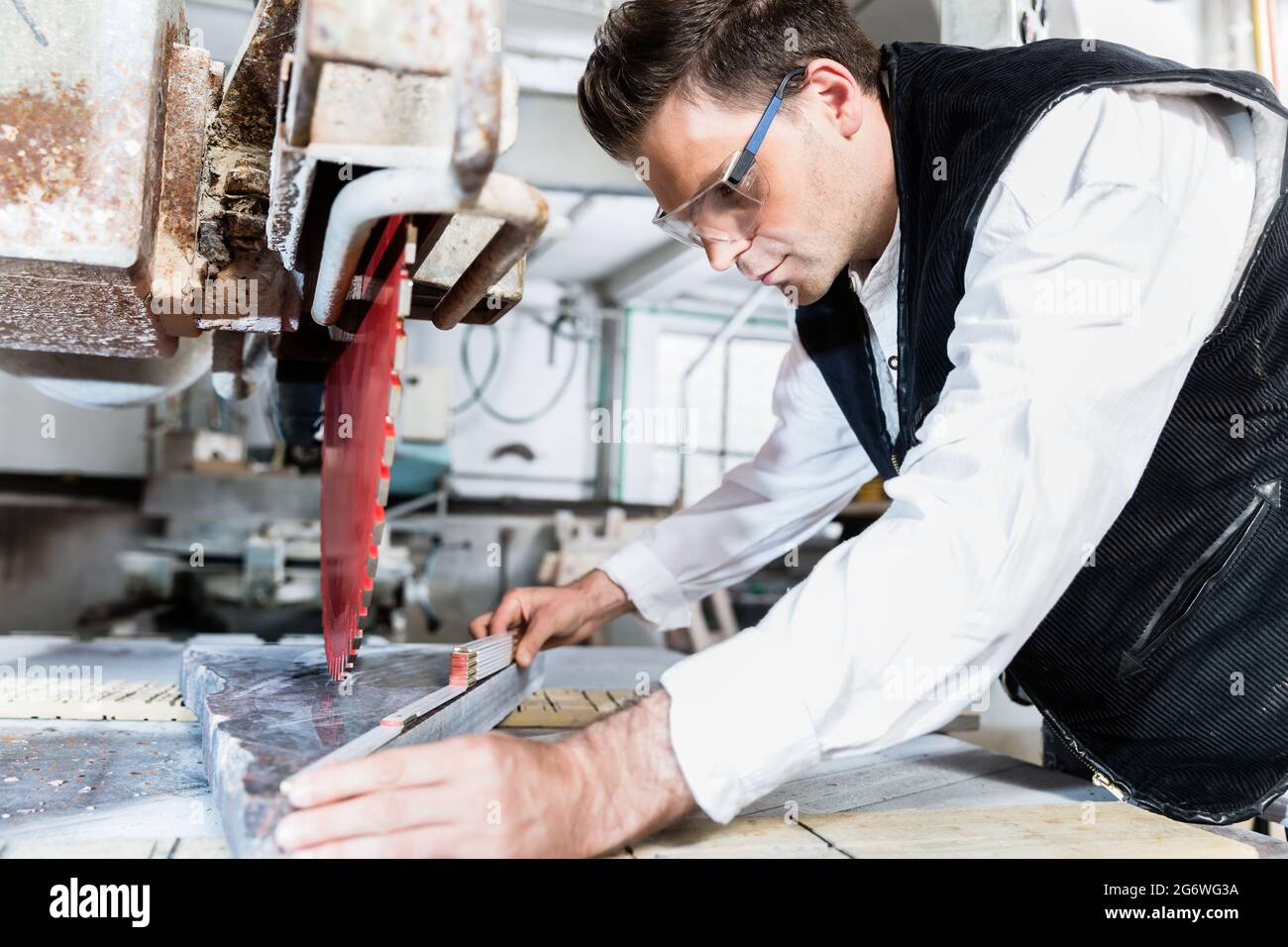 Craftsman measuring stone plate for sawing on diamond saw Stock Photo ...