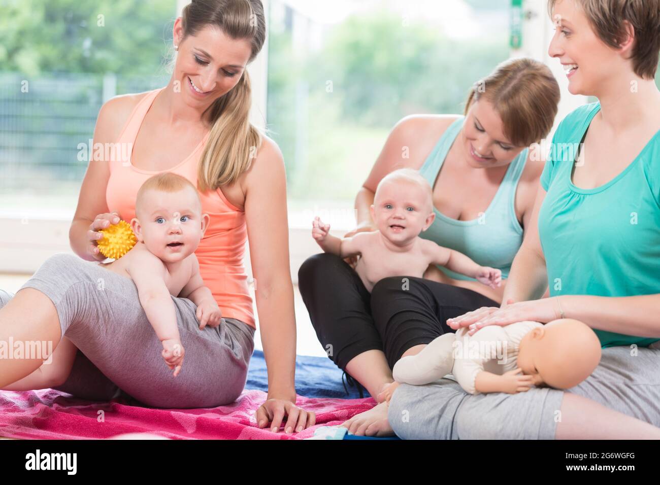 Young women practicing massage for their babies in mother-child class ...