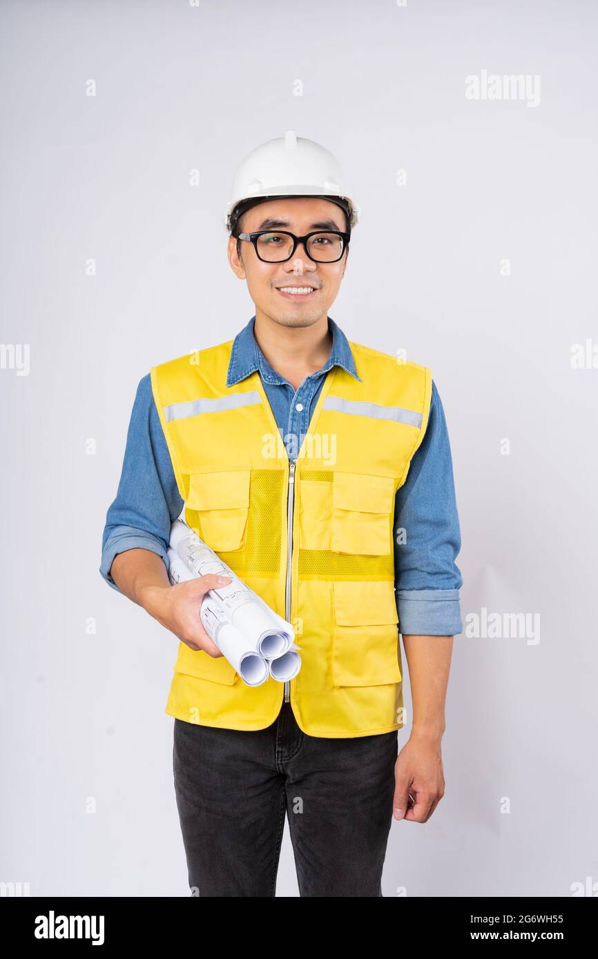 Smiling young asian civil engineer wearing helmet hard hat standing on ...